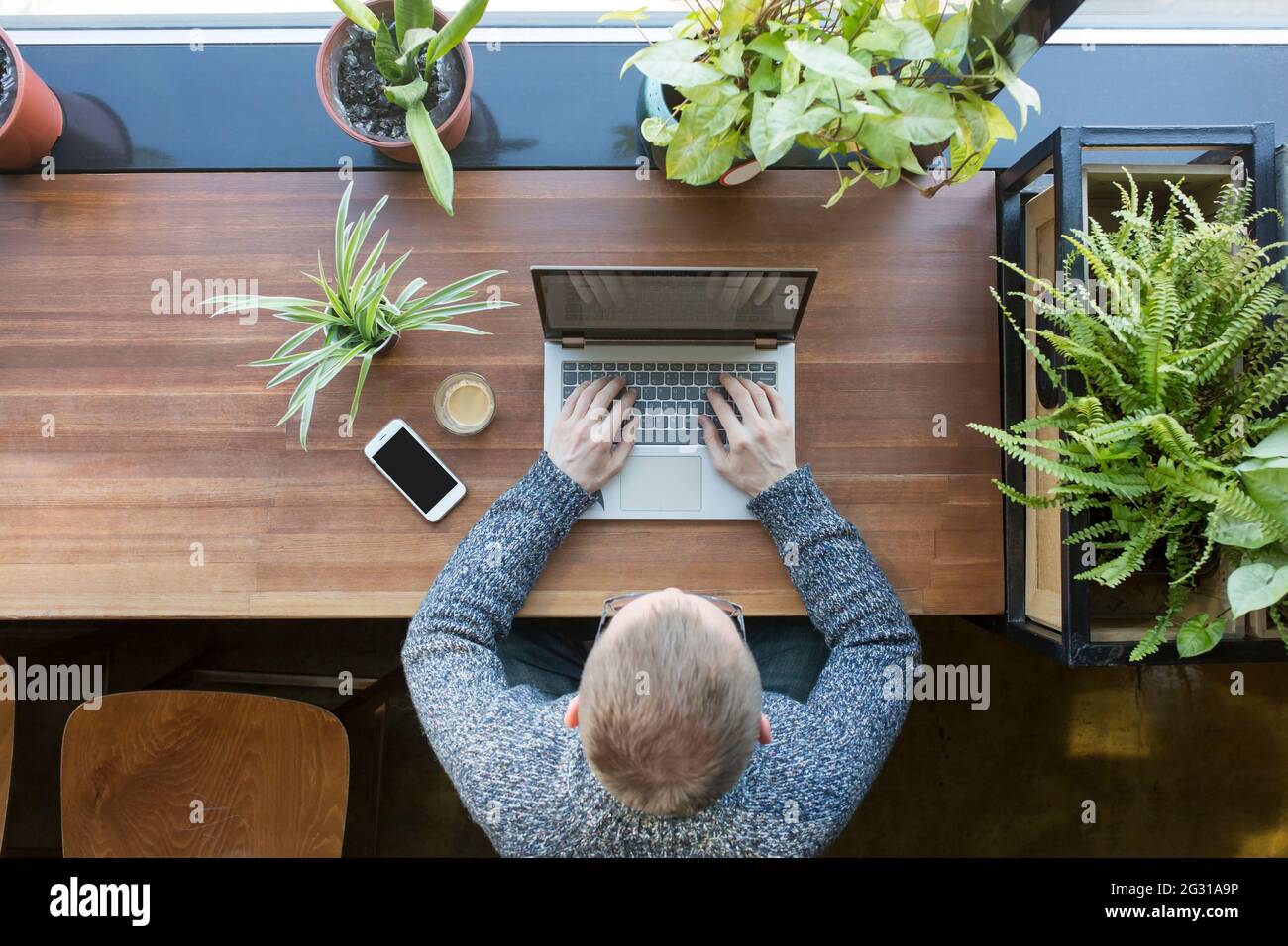 Busy businessman working at wooden desk using laptop Stock Photo - Alamy