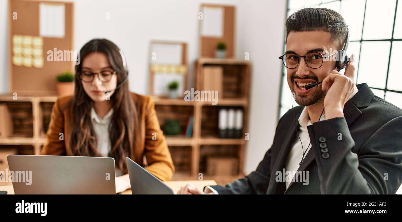 Two hispanic call center agents working at the office Stock Photo - Alamy