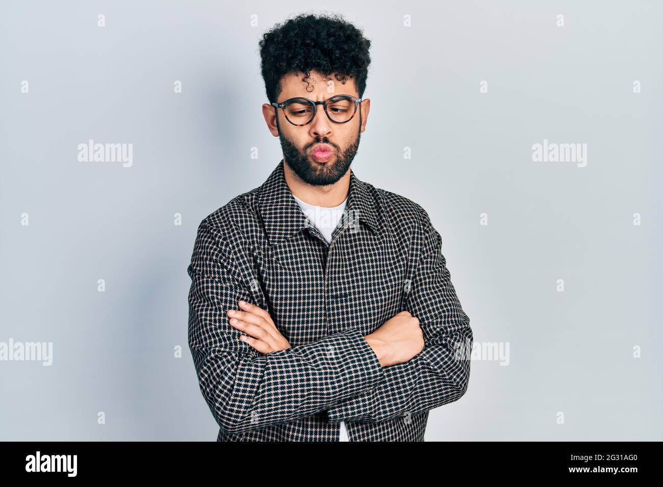 Young arab man with beard wearing glasses with arms crossed gesture ...