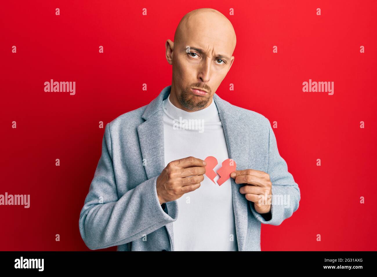 Bald man with beard holding broken heart paper shape depressed and ...