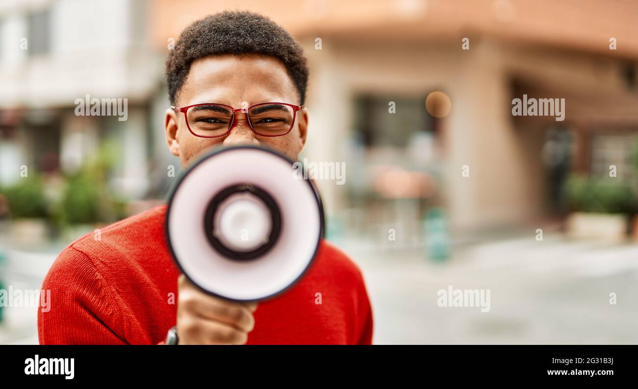 Handsome african american young man outdoors screaming through ...