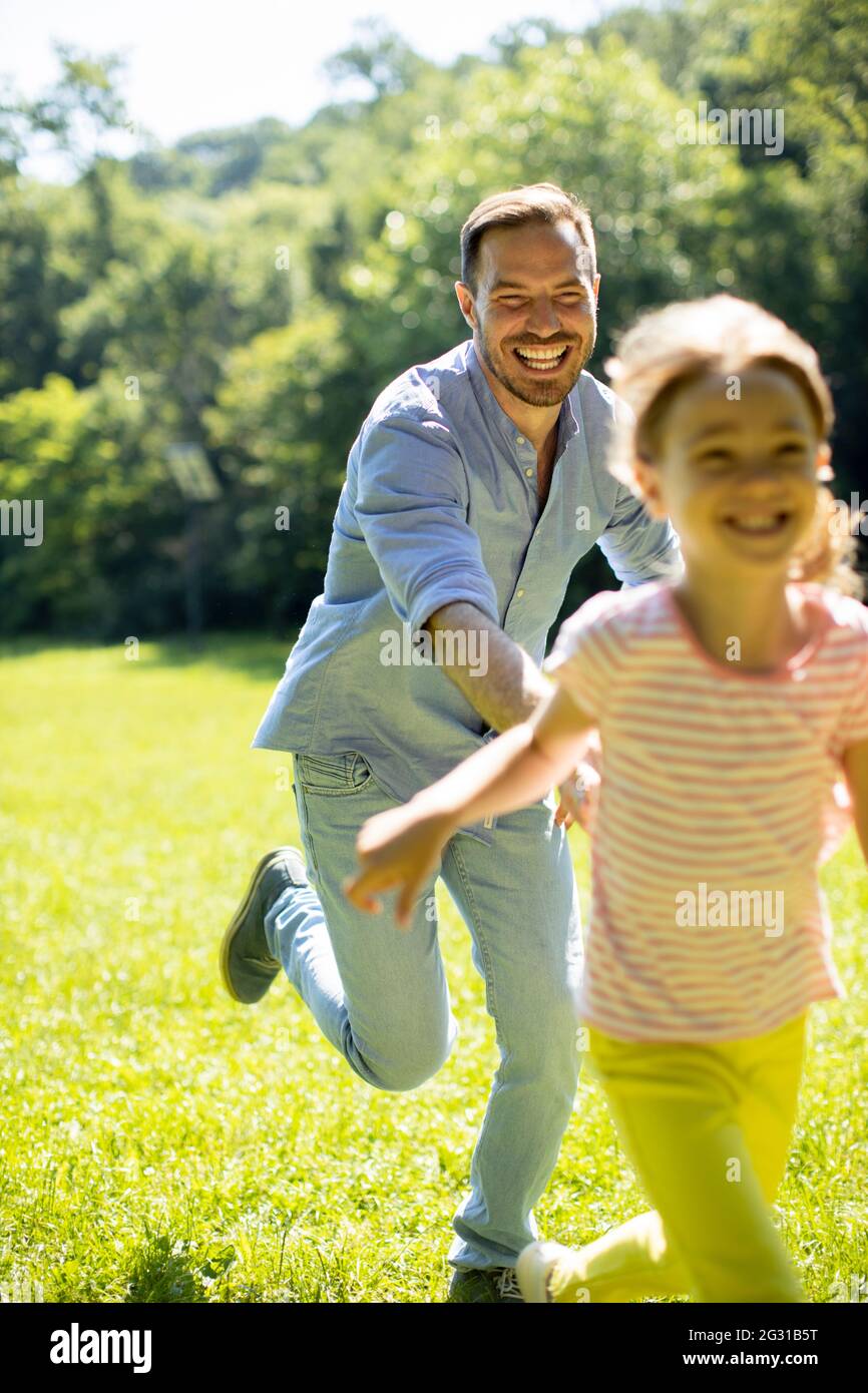 Father chasing his cute little daughter while playing in the park Stock ...