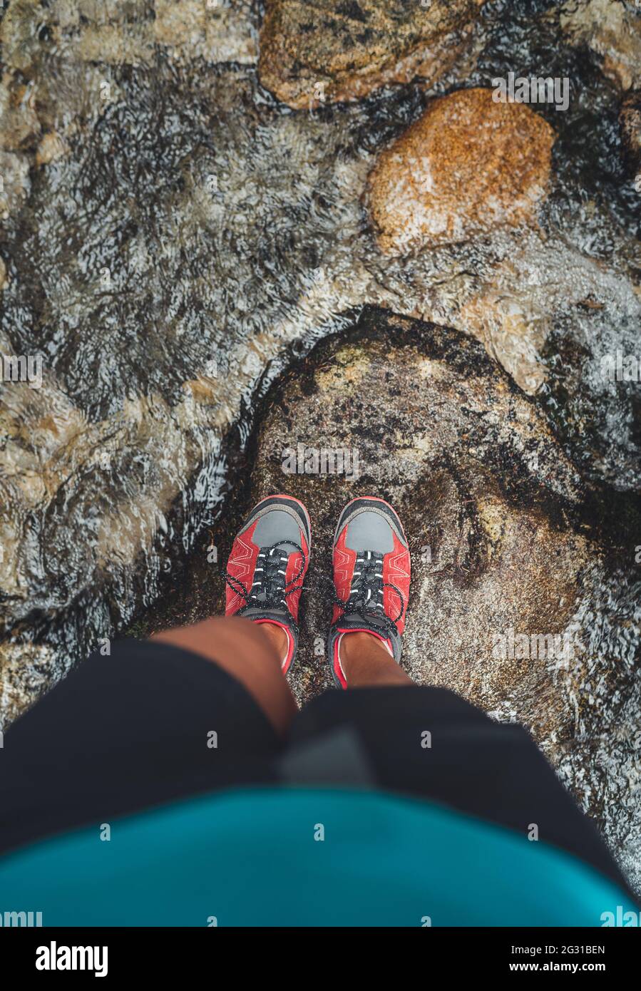 Female feet in trekking boots top view on the stone washed by fresh ...