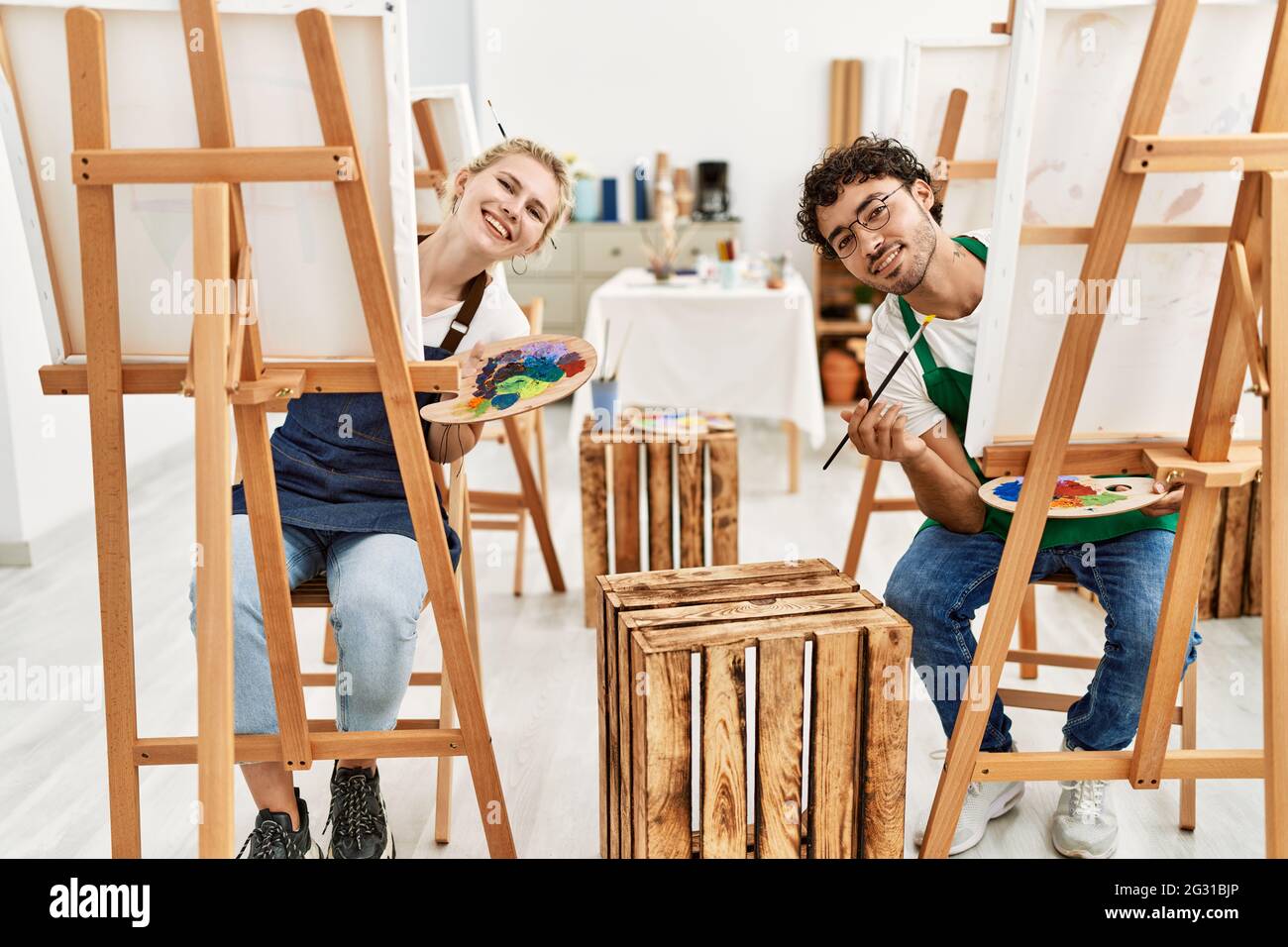 Young artist couple smiling happy painting at art studio Stock Photo ...
