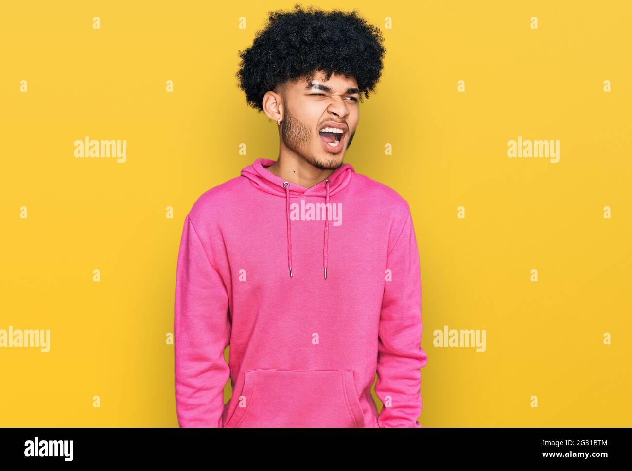 Young african american man with afro hair wearing casual pink ...