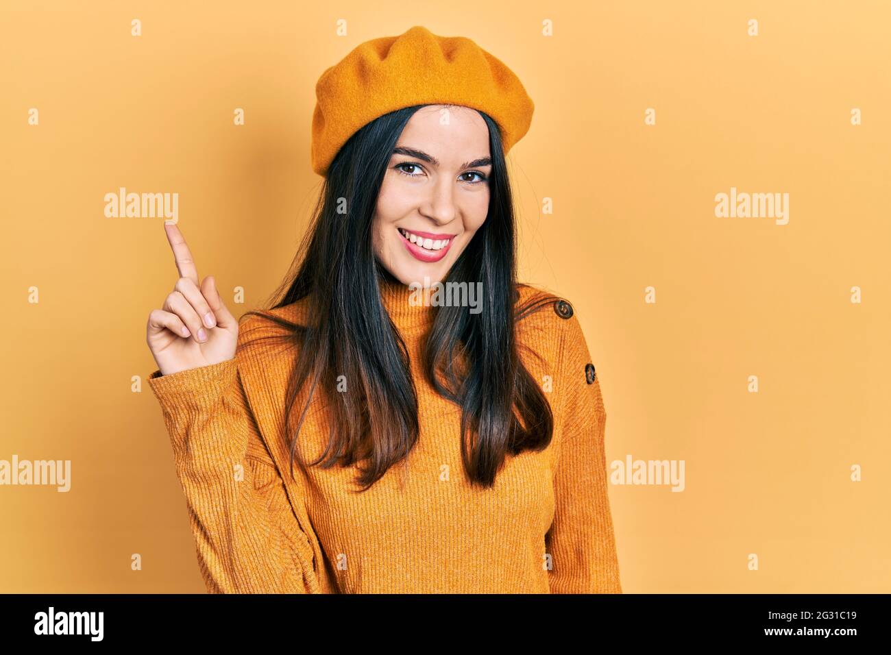 Young brunette woman wearing french look with beret smiling with an ...