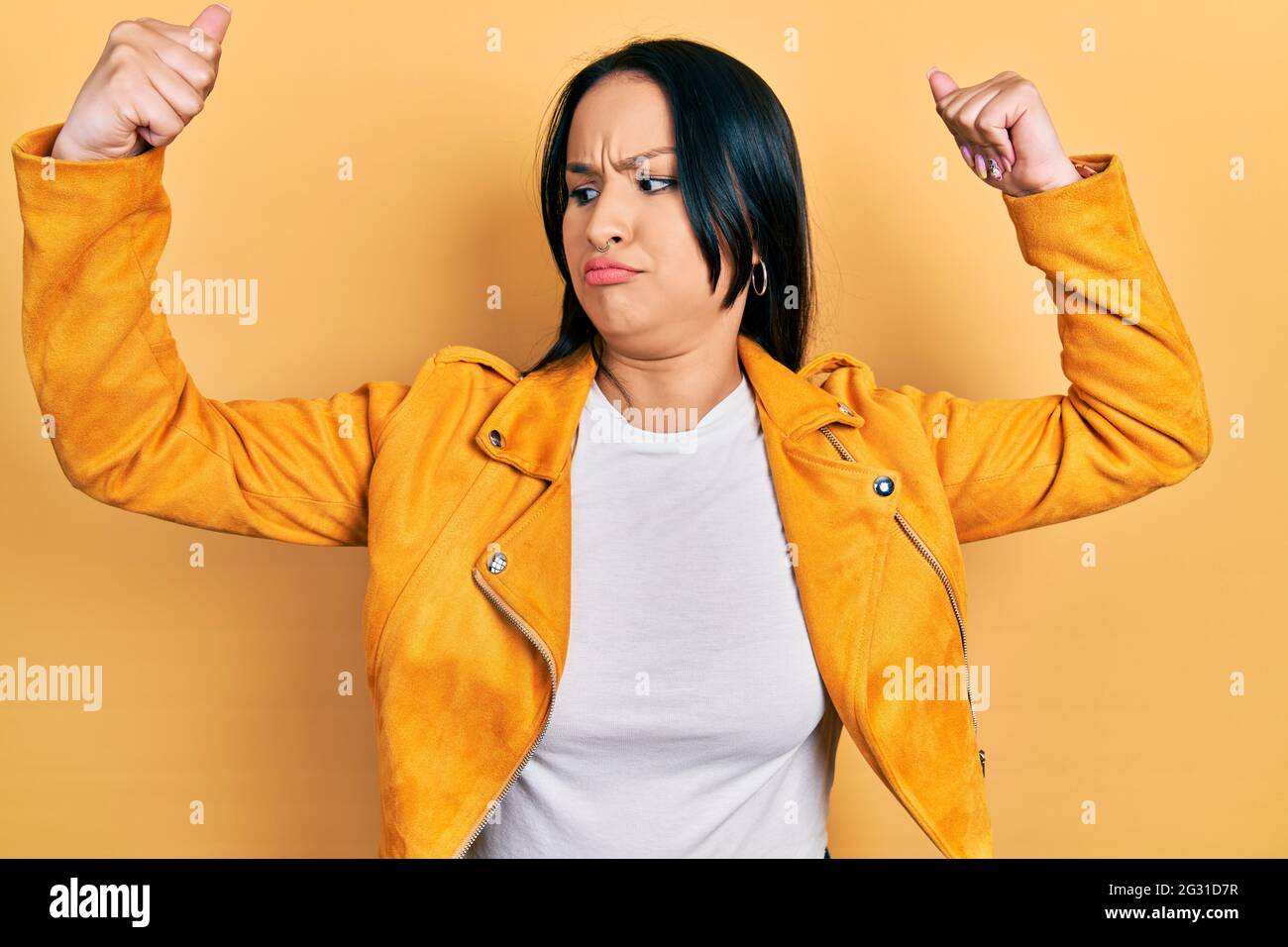 Beautiful hispanic woman with nose piercing wearing yellow leather ...