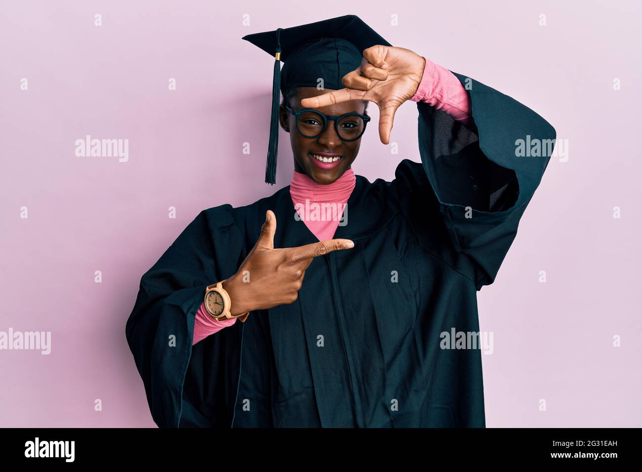 Young african american girl wearing graduation cap and ceremony robe ...
