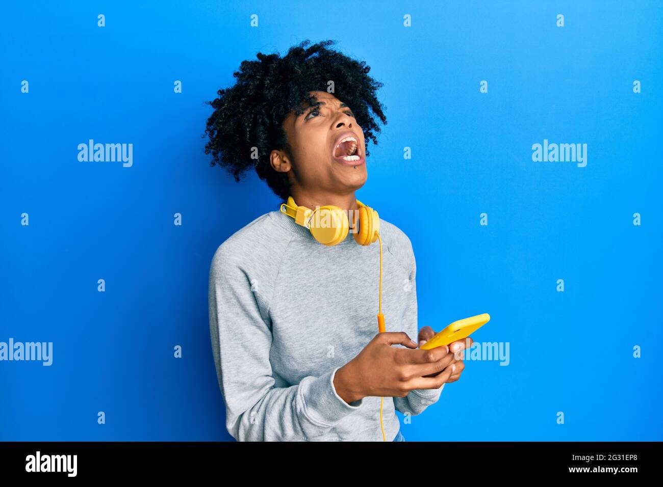 African american woman with afro hair using smartphone typing message ...