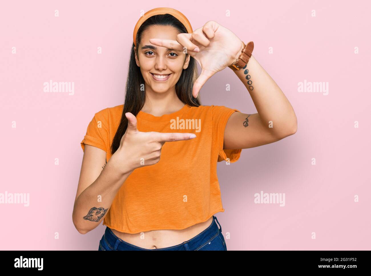 Young hispanic woman wearing casual clothes smiling making frame with ...