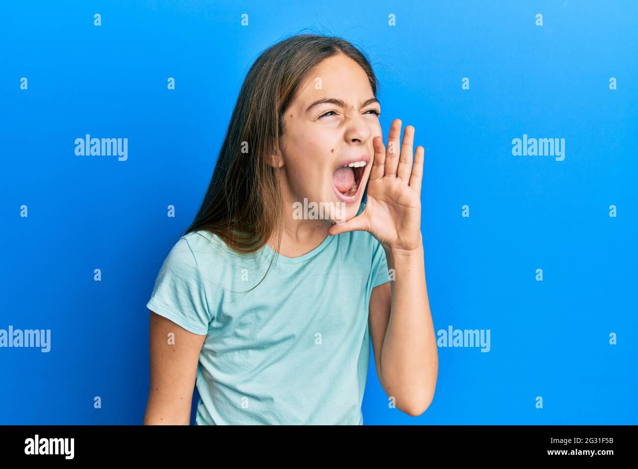 Beautiful brunette little girl wearing casual white t shirt shouting ...