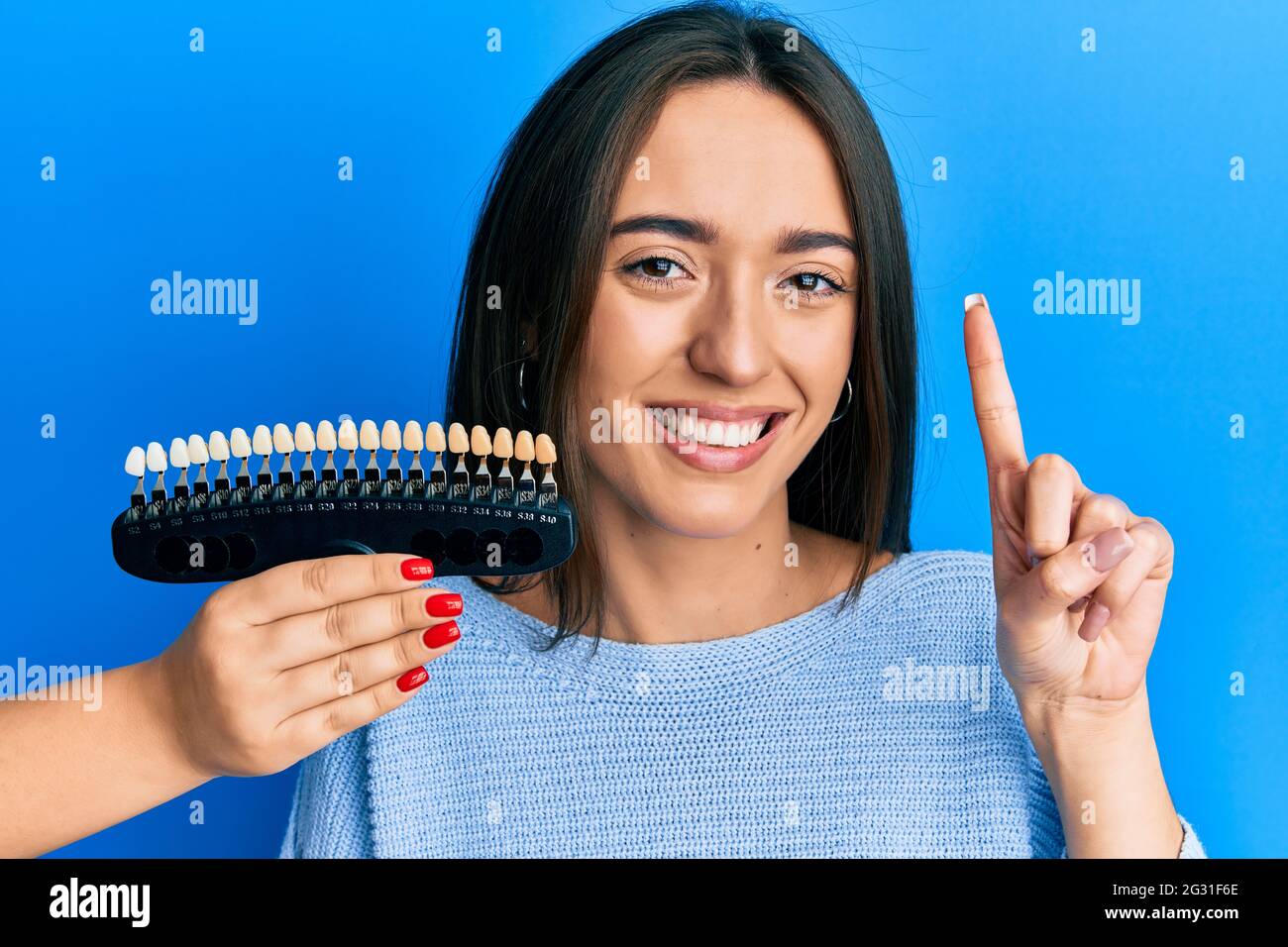 Young hispanic girl comparing teeth whitening smiling with an idea or ...