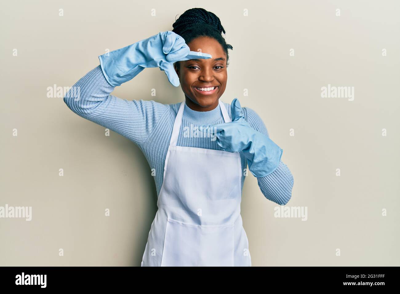 African american woman with braided hair wearing cleaner apron and ...
