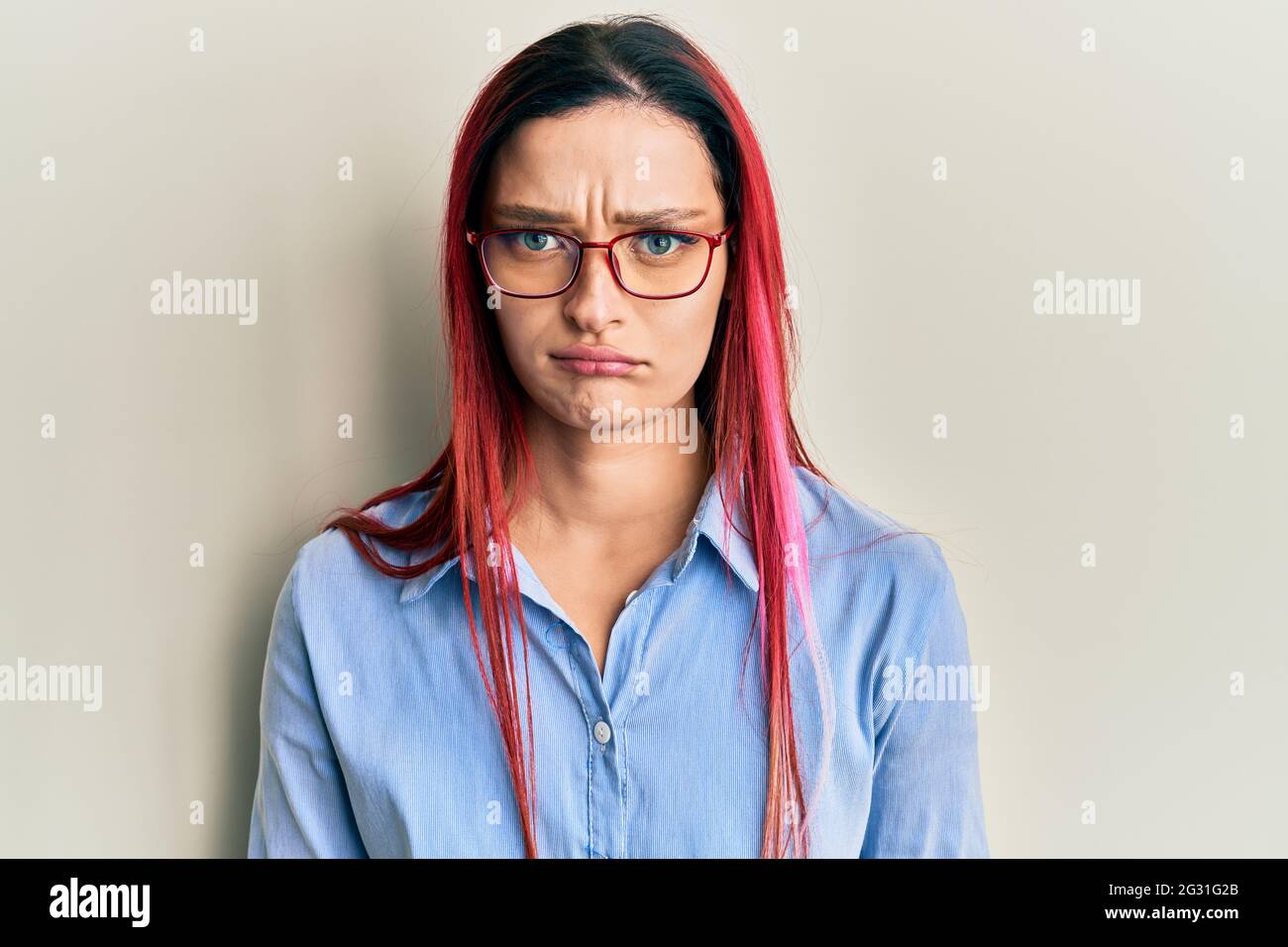 Young caucasian woman wearing casual clothes and glasses skeptic and ...
