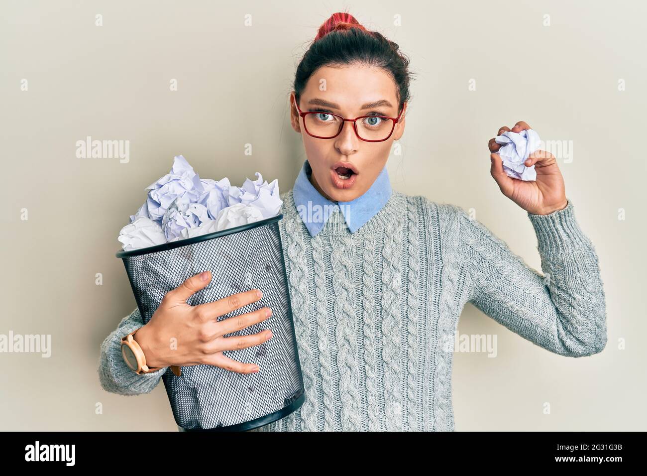 Young caucasian woman holding paper bin full of crumpled papers scared ...