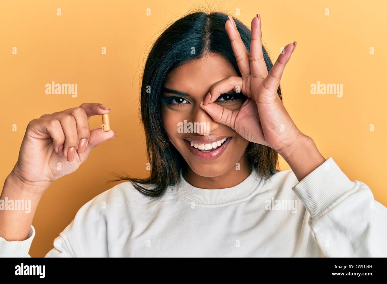 Young latin transsexual transgender woman holding pill smiling happy ...