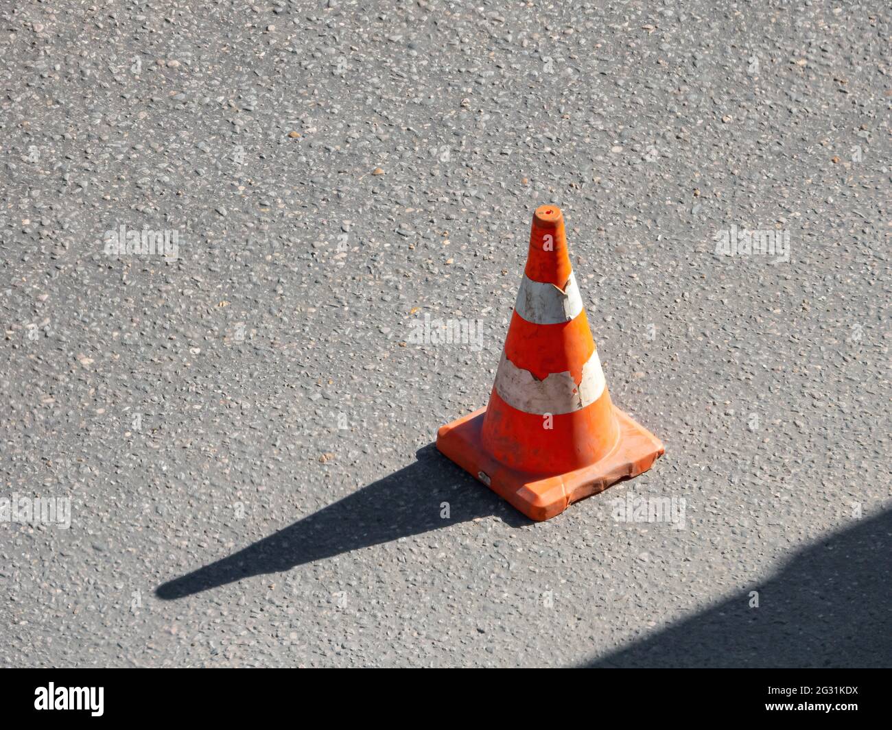 Old traffic cone standing on the asphalt road Stock Photo - Alamy