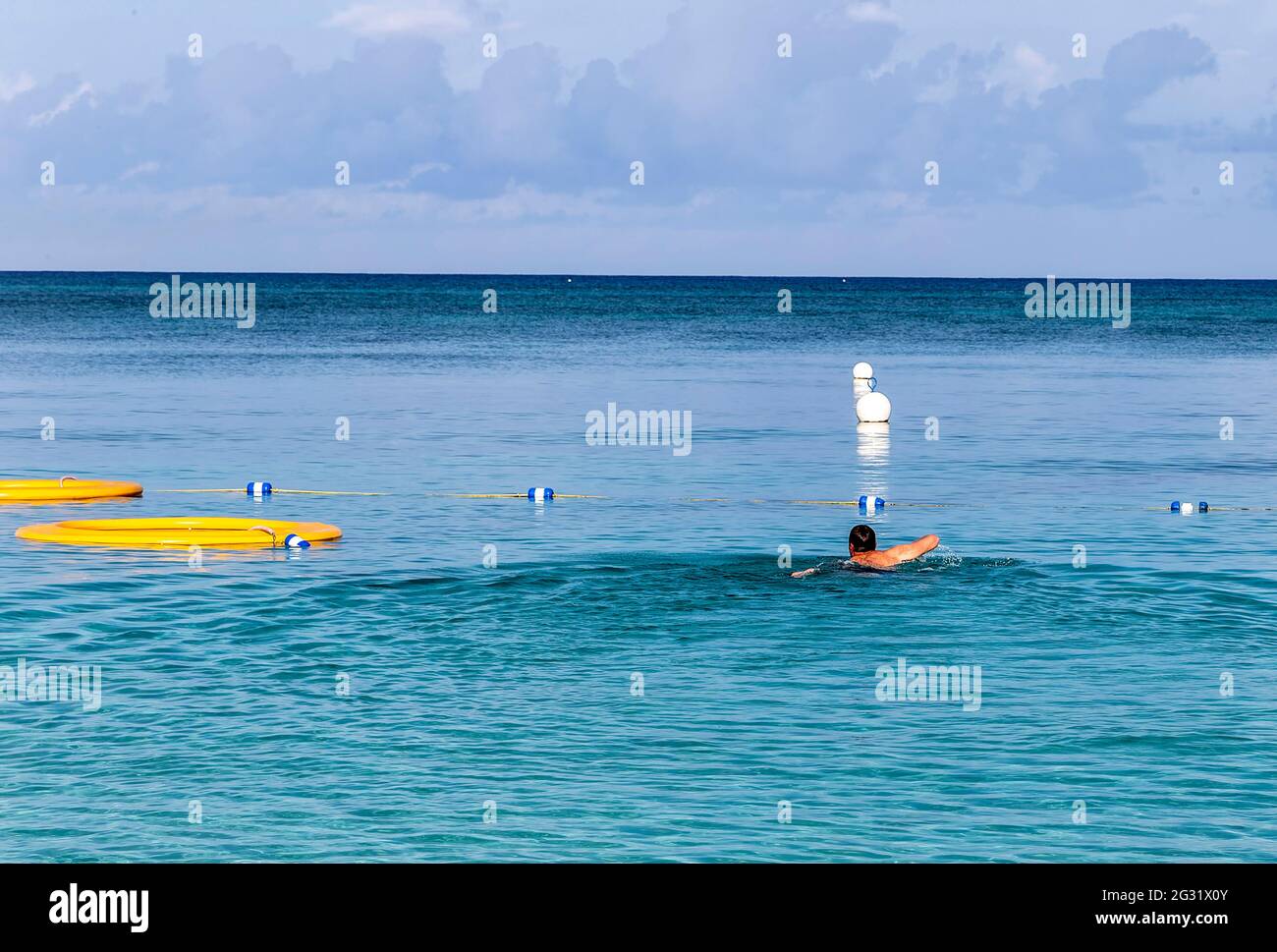 Early morning swimmer at a Caribbean beach resort Stock Photo - Alamy