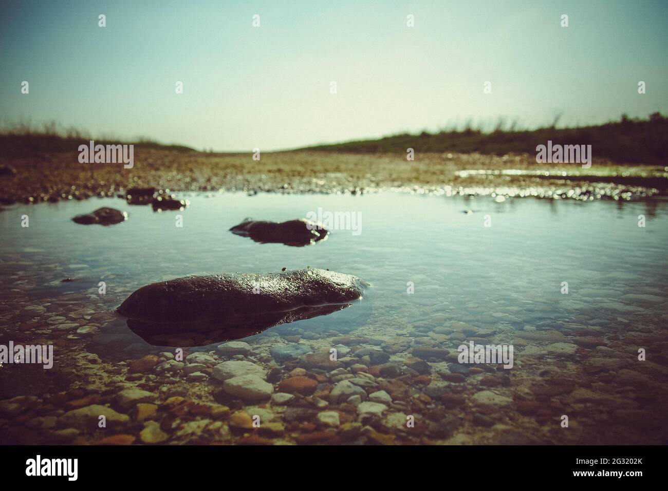 A small lake with stones visible through the clear water Stock Photo ...