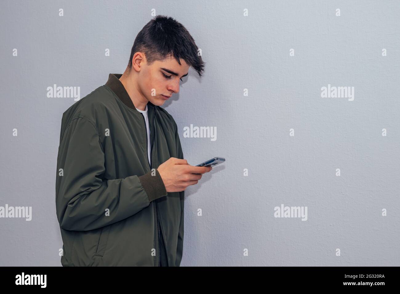 teenager boy with mobile phone at home wall isolated Stock Photo - Alamy