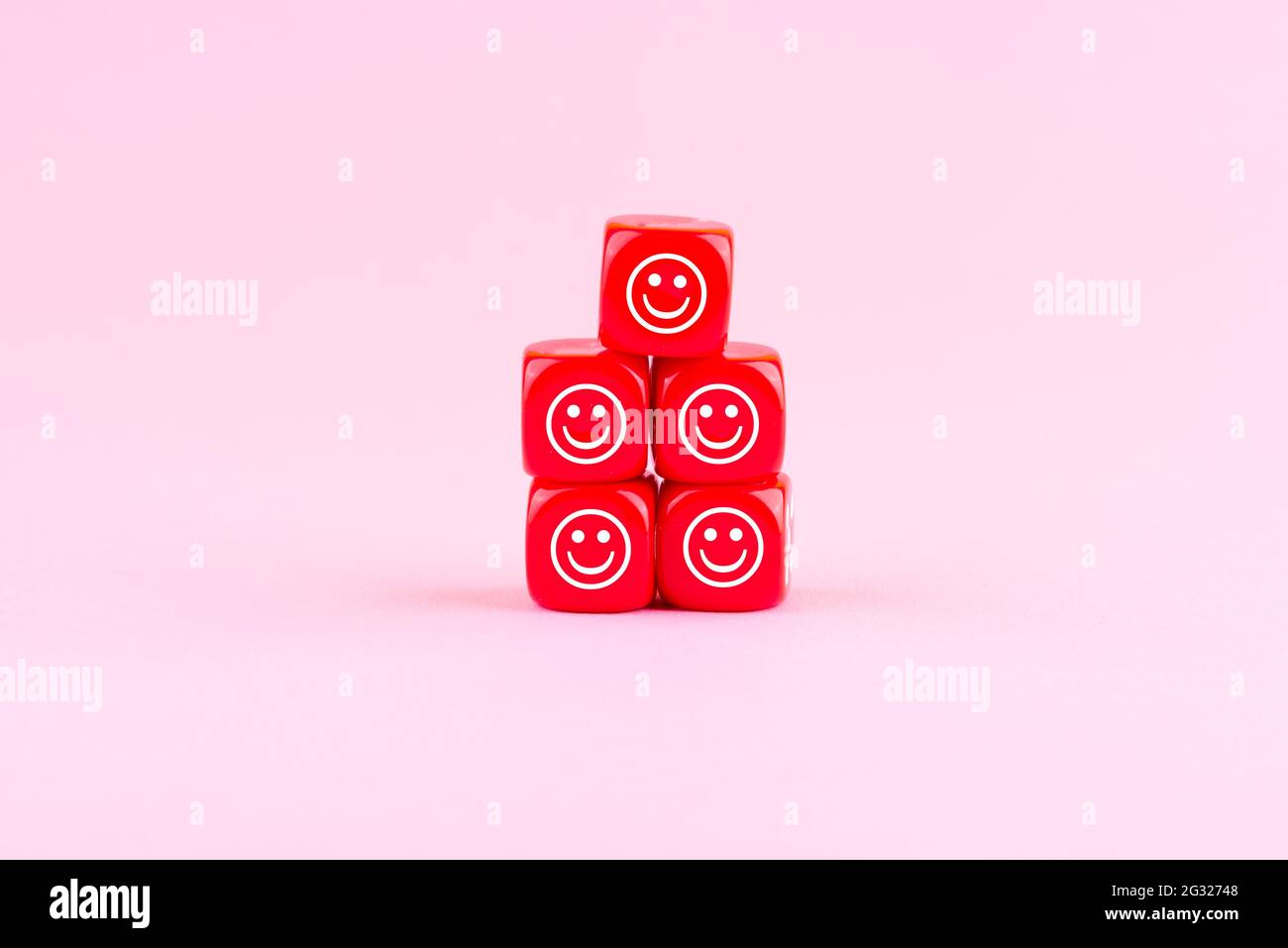 A closeup shot of 5 red blocks with symbols of happy smiley faces ...
