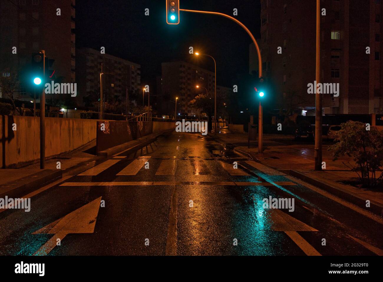 green traffic lights on a rainy day with reflection on wet street at ...