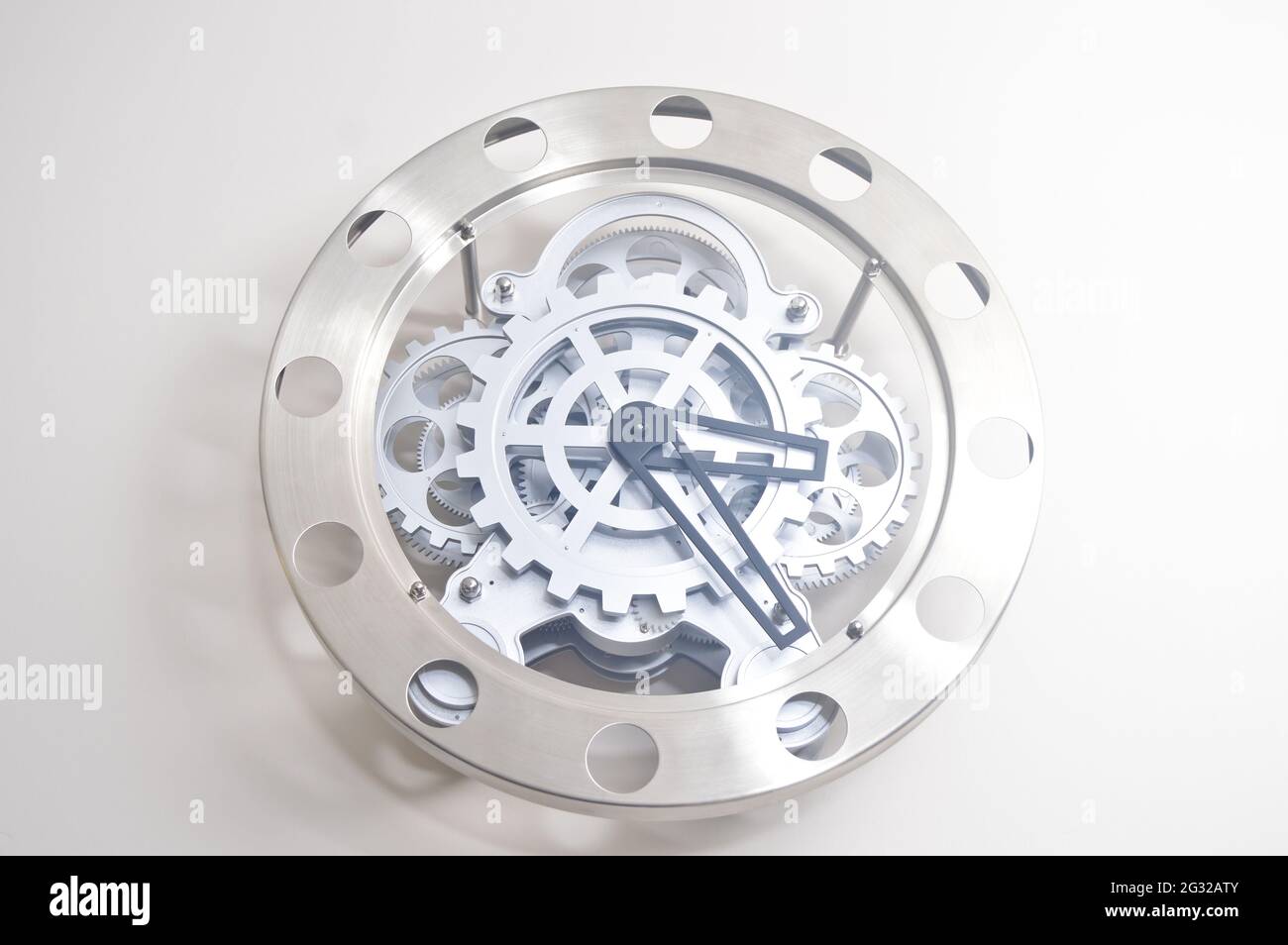 A modern wall clock hanging on the wall made of metal wheels Stock ...