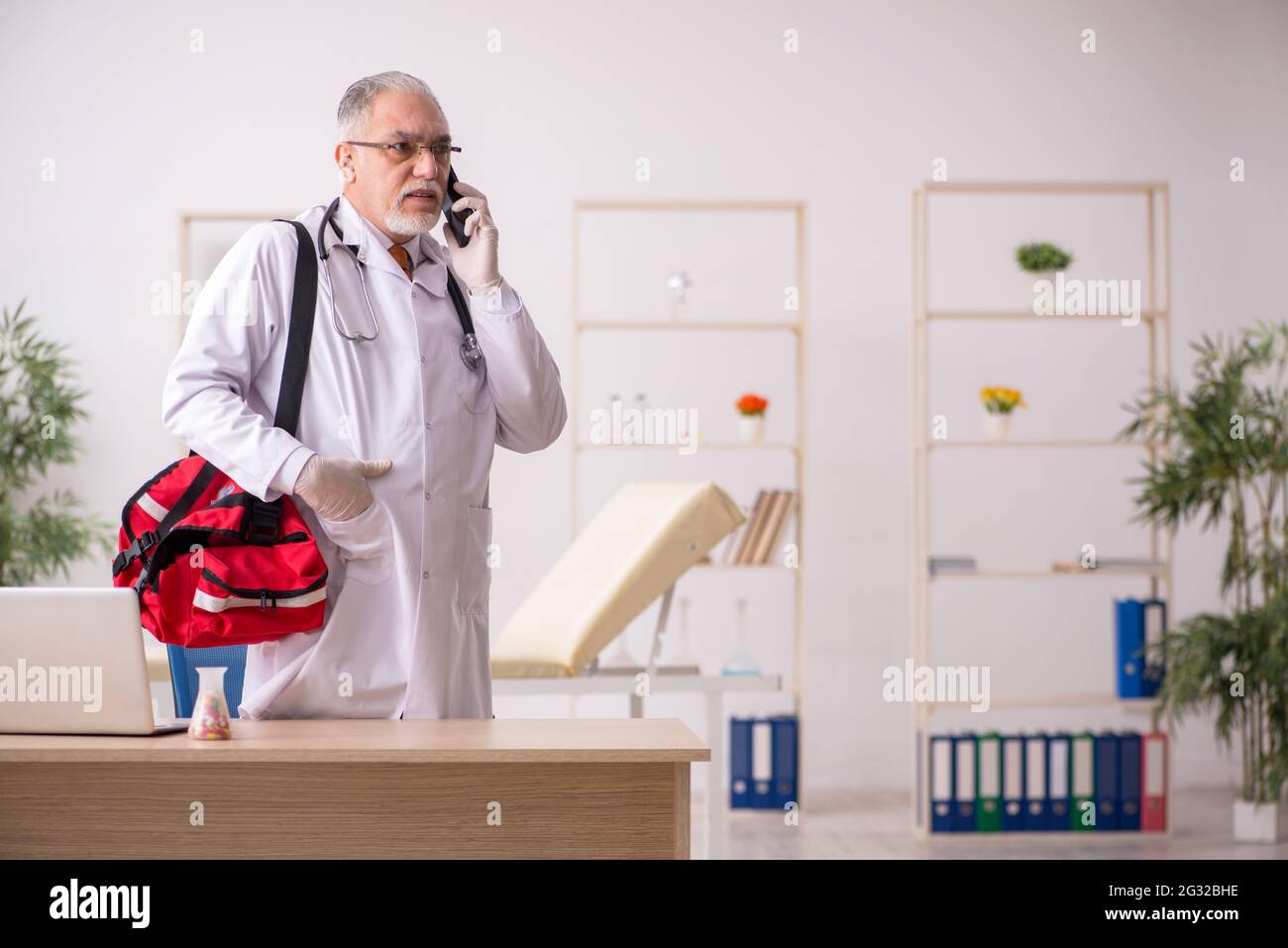 Old doctor in first aid concept Stock Photo - Alamy