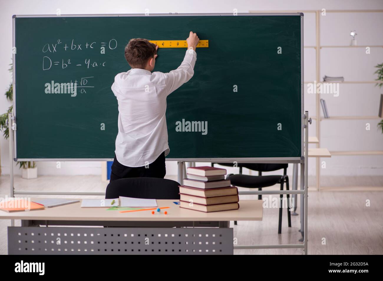 Schoolboy studying geometry in front of chalkboard Stock Photo - Alamy