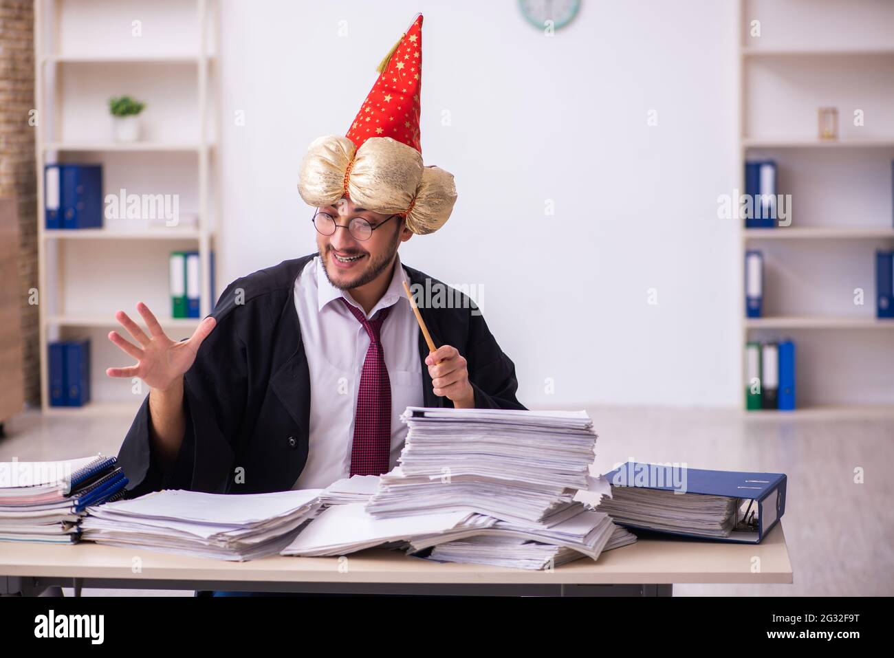 Funny young employee magician and too much work in the office Stock ...