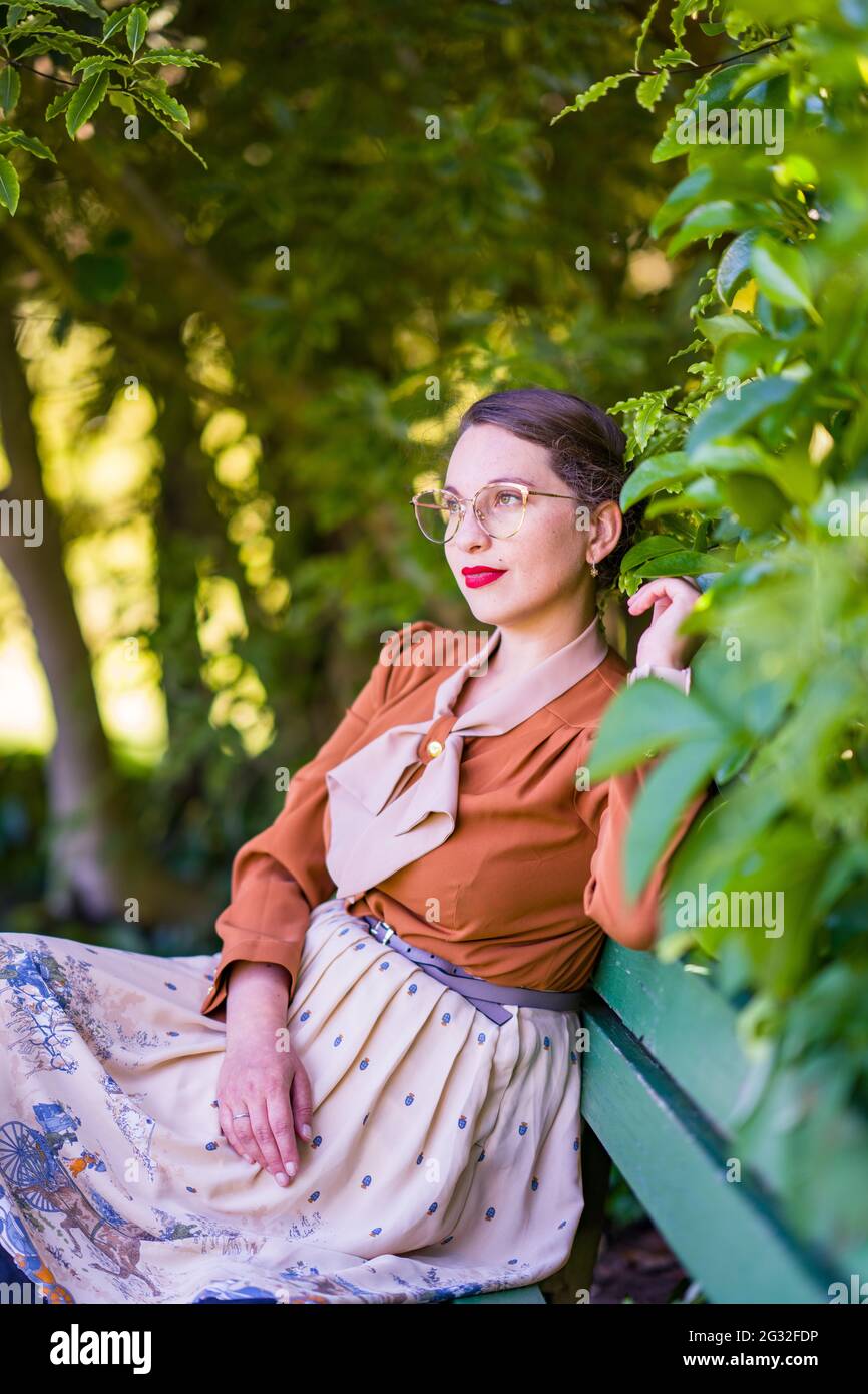 Young Intellectual Woman Dressed in 1940s Clothing In a Garden Stock ...