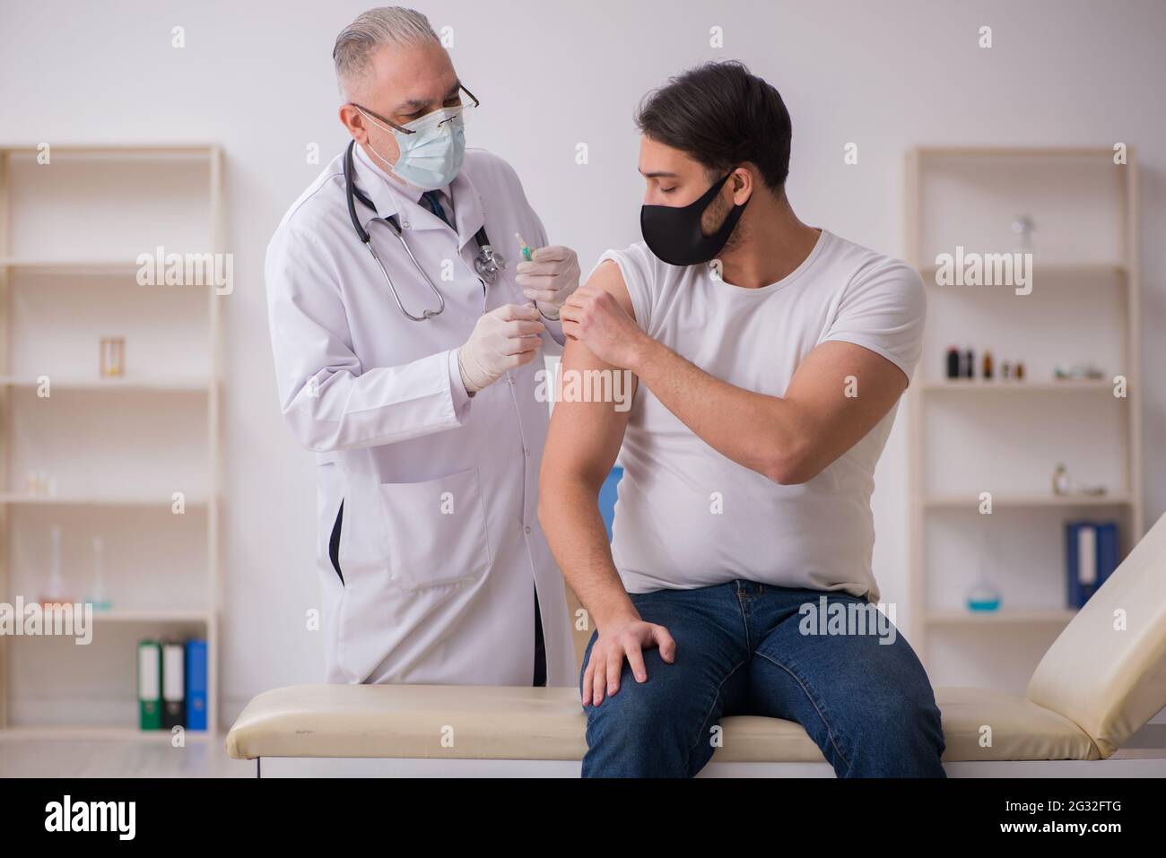 Young patient visiting old doctor in vaccination concept Stock Photo ...