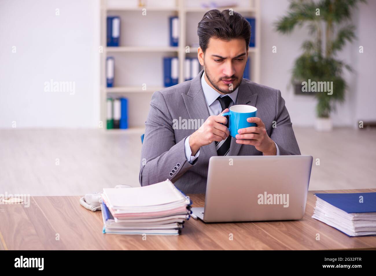 Young male employee having break at workplace Stock Photo - Alamy