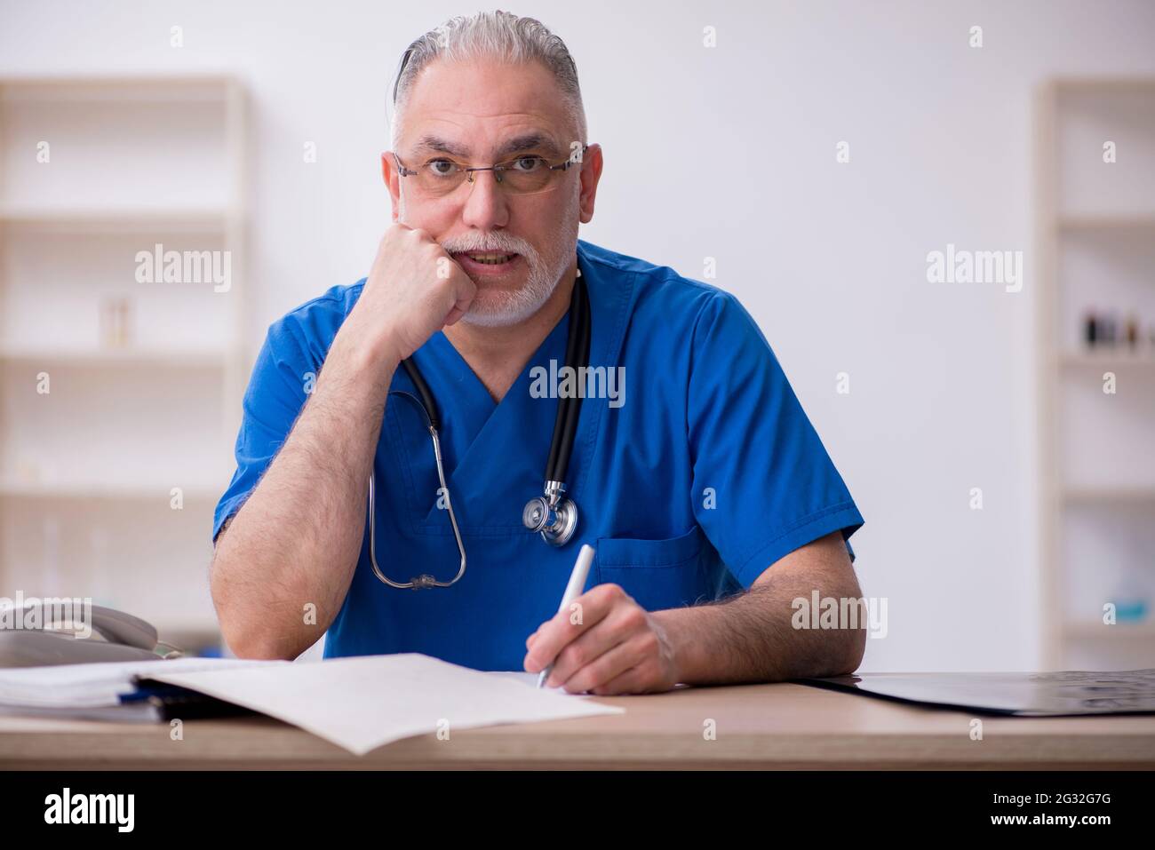 Experienced male doctor working in the clinic Stock Photo - Alamy