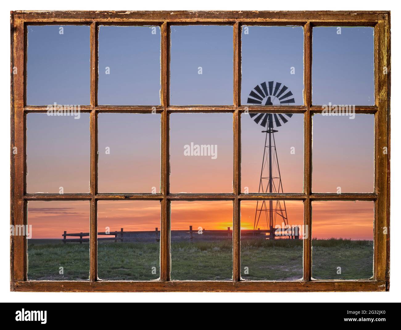windmill with a water pump and tank against sunrise in a prairie as ...