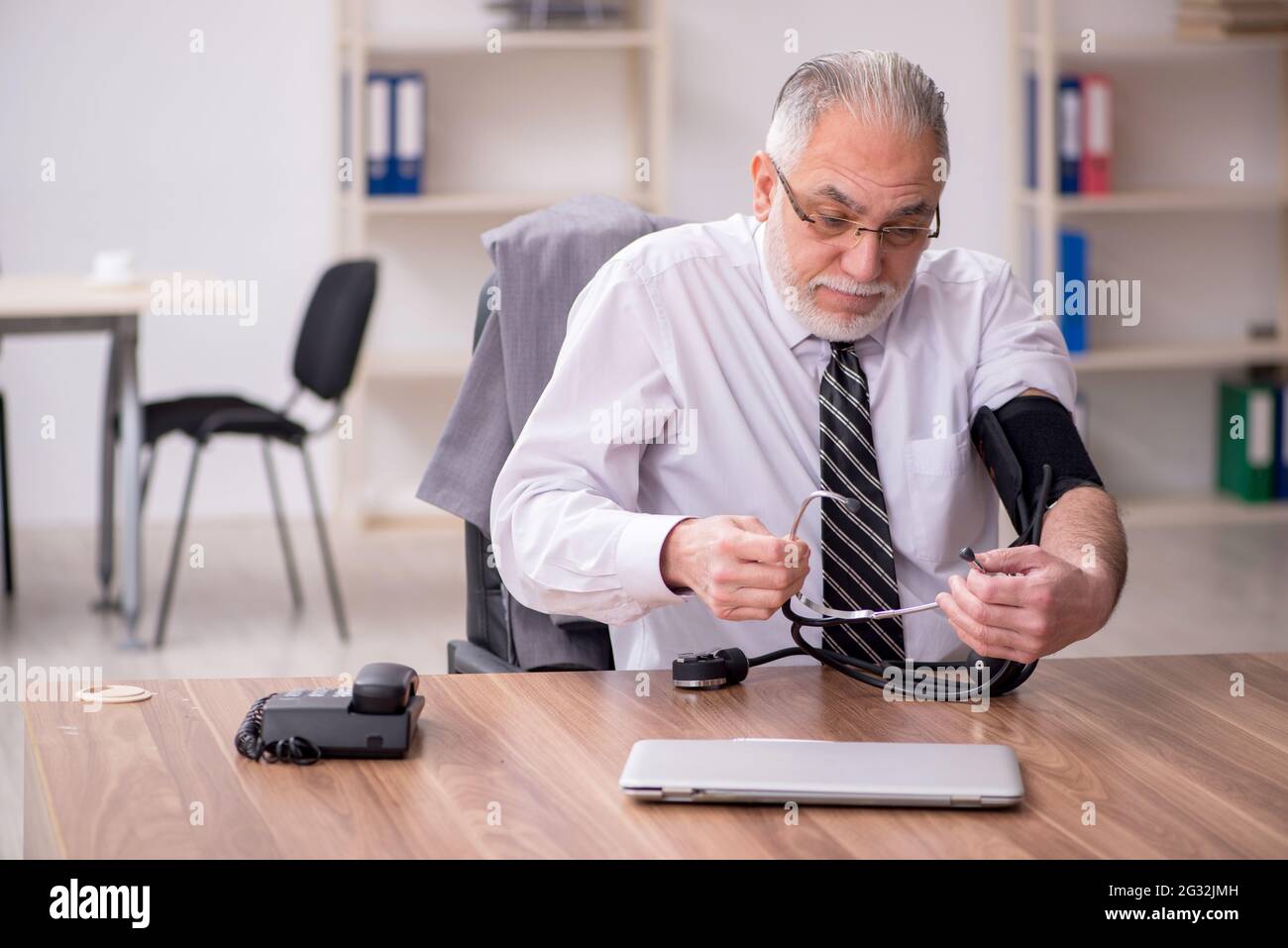 Aged male employee feeling bad in the office Stock Photo - Alamy