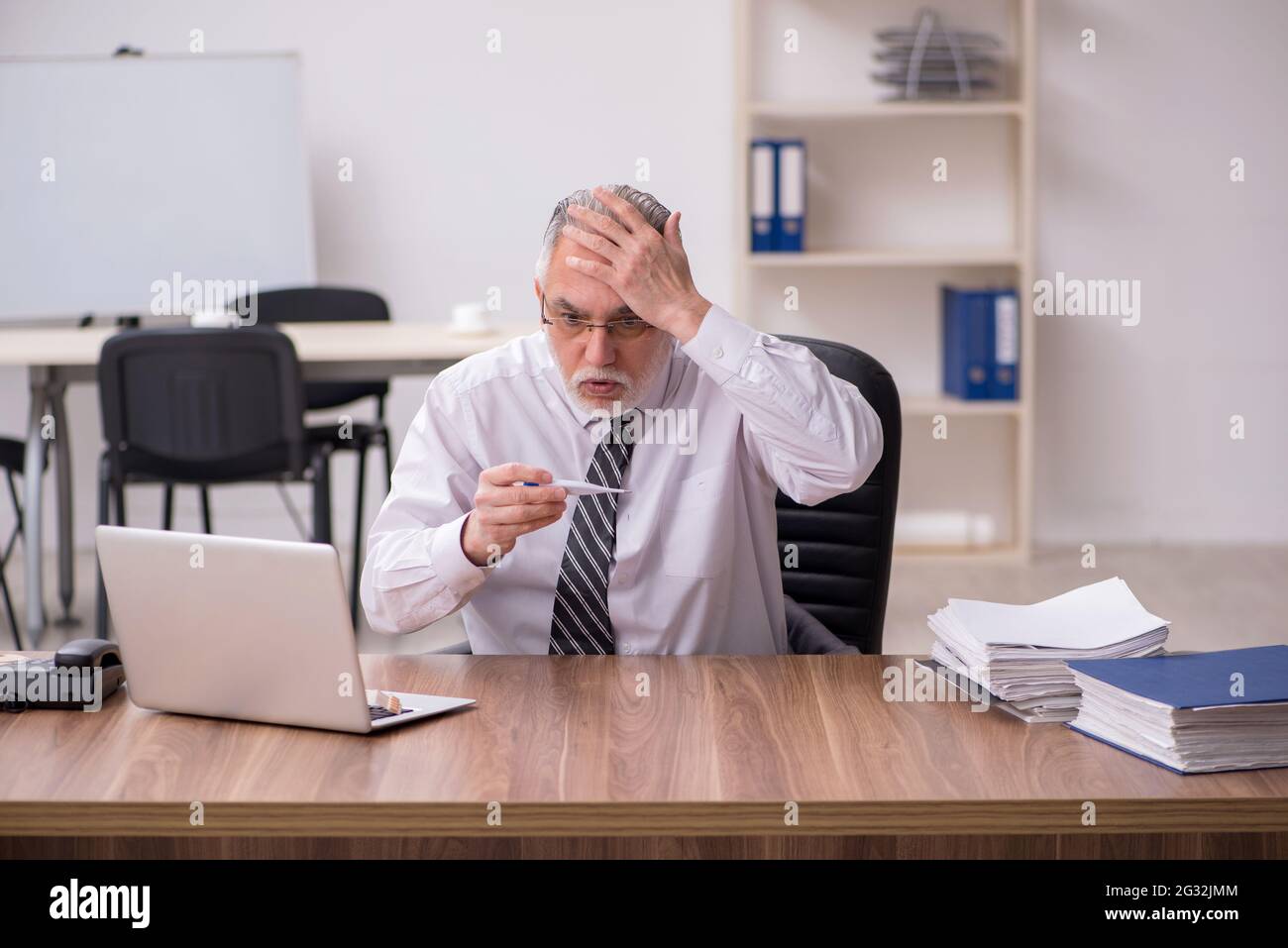 Aged male employee feeling bad in the office Stock Photo - Alamy