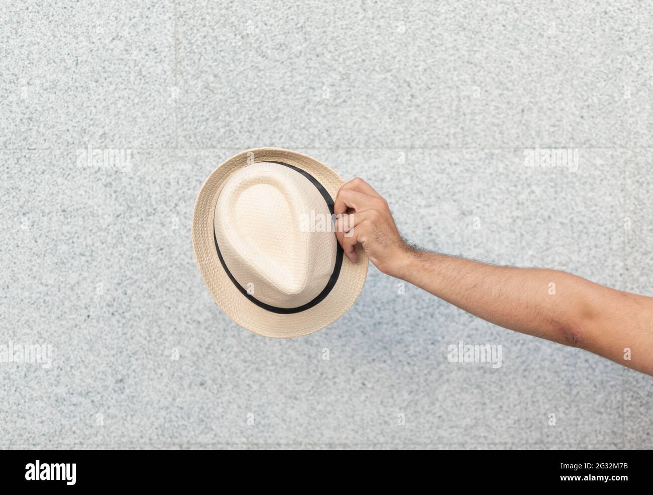 Hand of unrecognizable person holding a Fedora hat with a stone ...