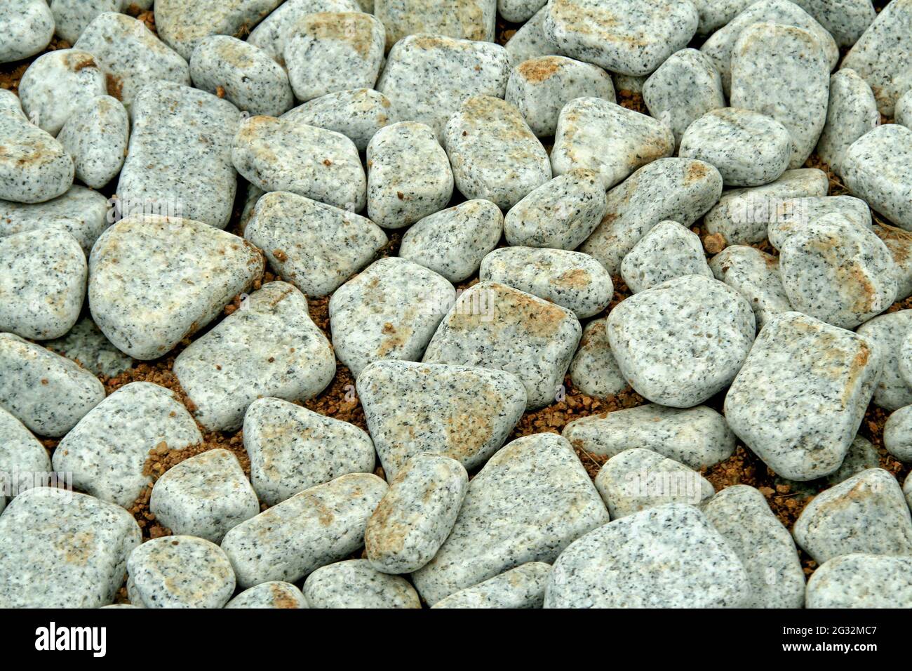 Pavement covered with round-edged grey pebbles Stock Photo - Alamy