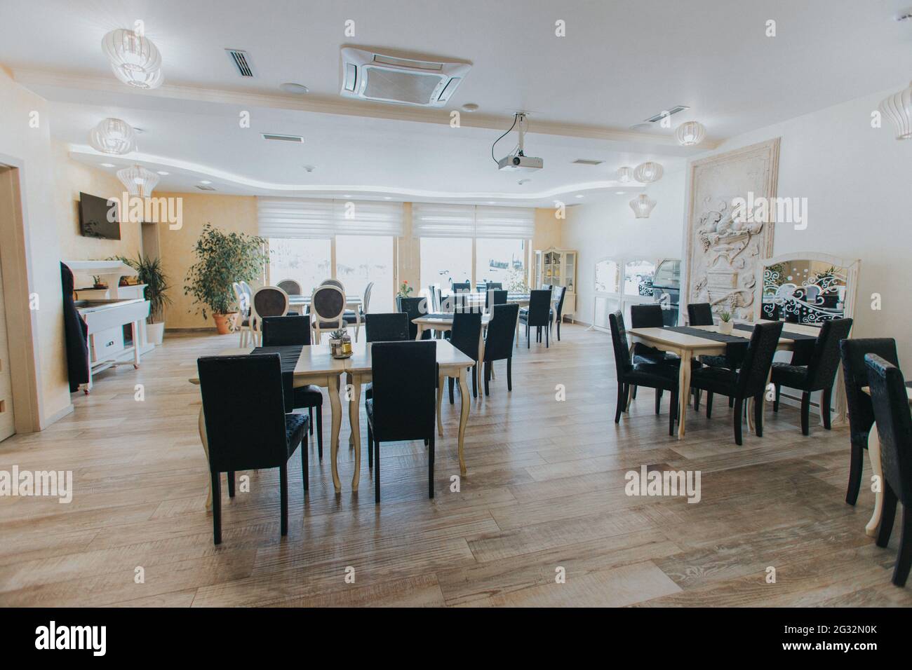 A restaurant empty room decor with tables and chairs in white and black ...