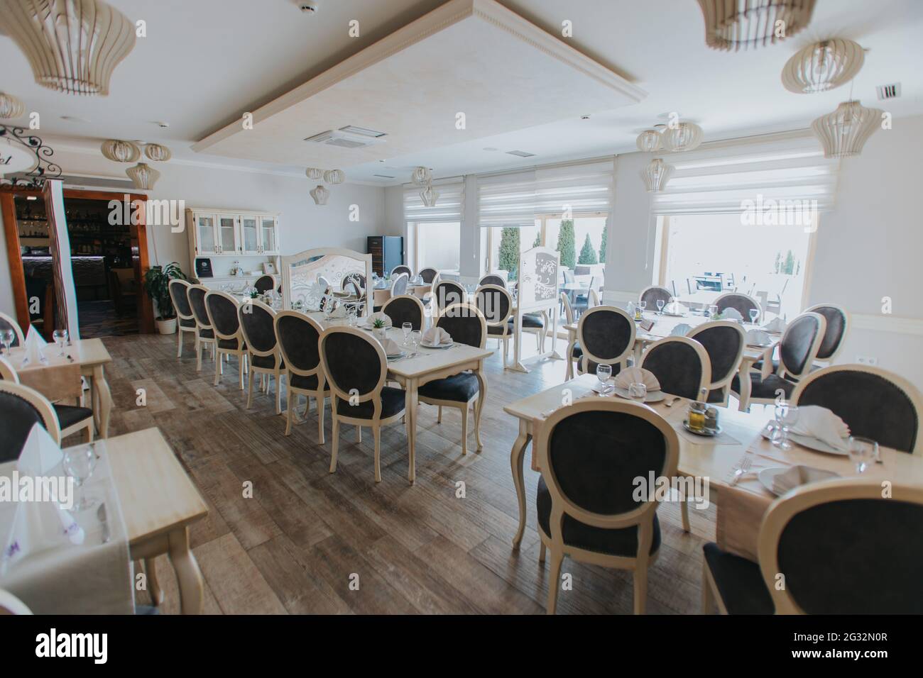 A restaurant empty room decor with tables and chairs in white and black ...