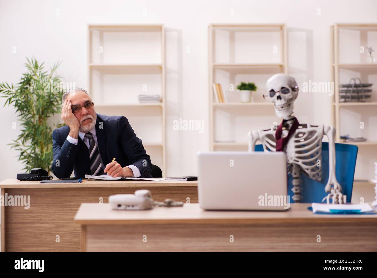 Dead employee working in the office in funny concept Stock Photo - Alamy