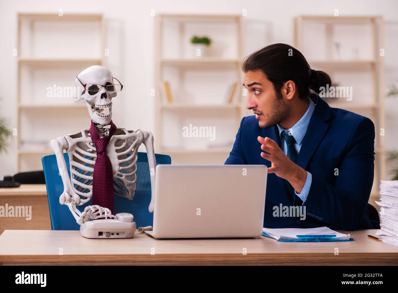 Dead employee working in the office in funny concept Stock Photo - Alamy