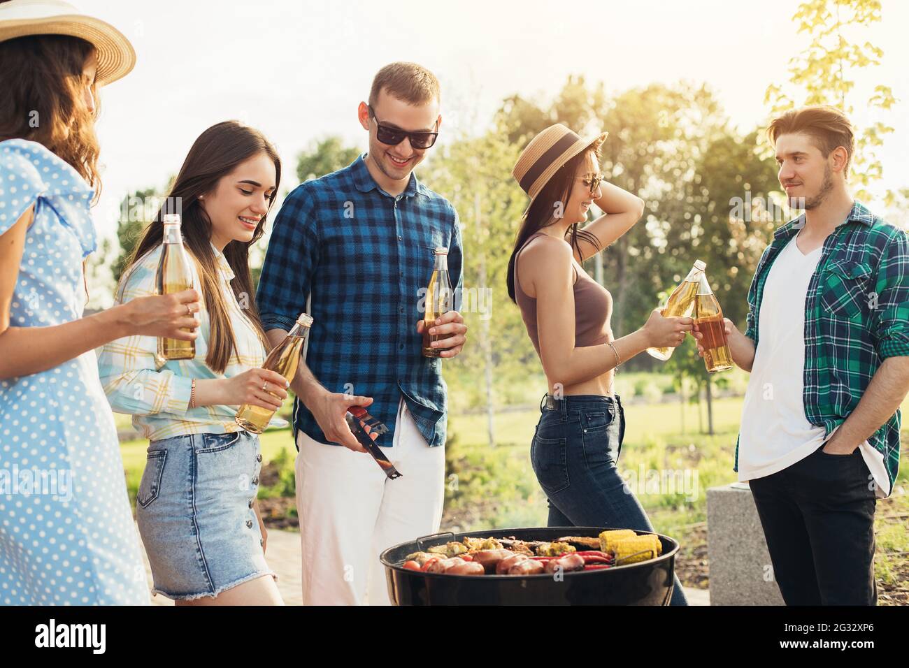 Friends having barbecue party in nature, barbecue laughing with drinks ...