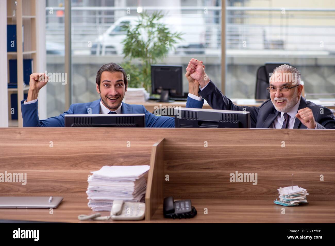 Two businessmen celebrating desk hi-res stock photography and images ...