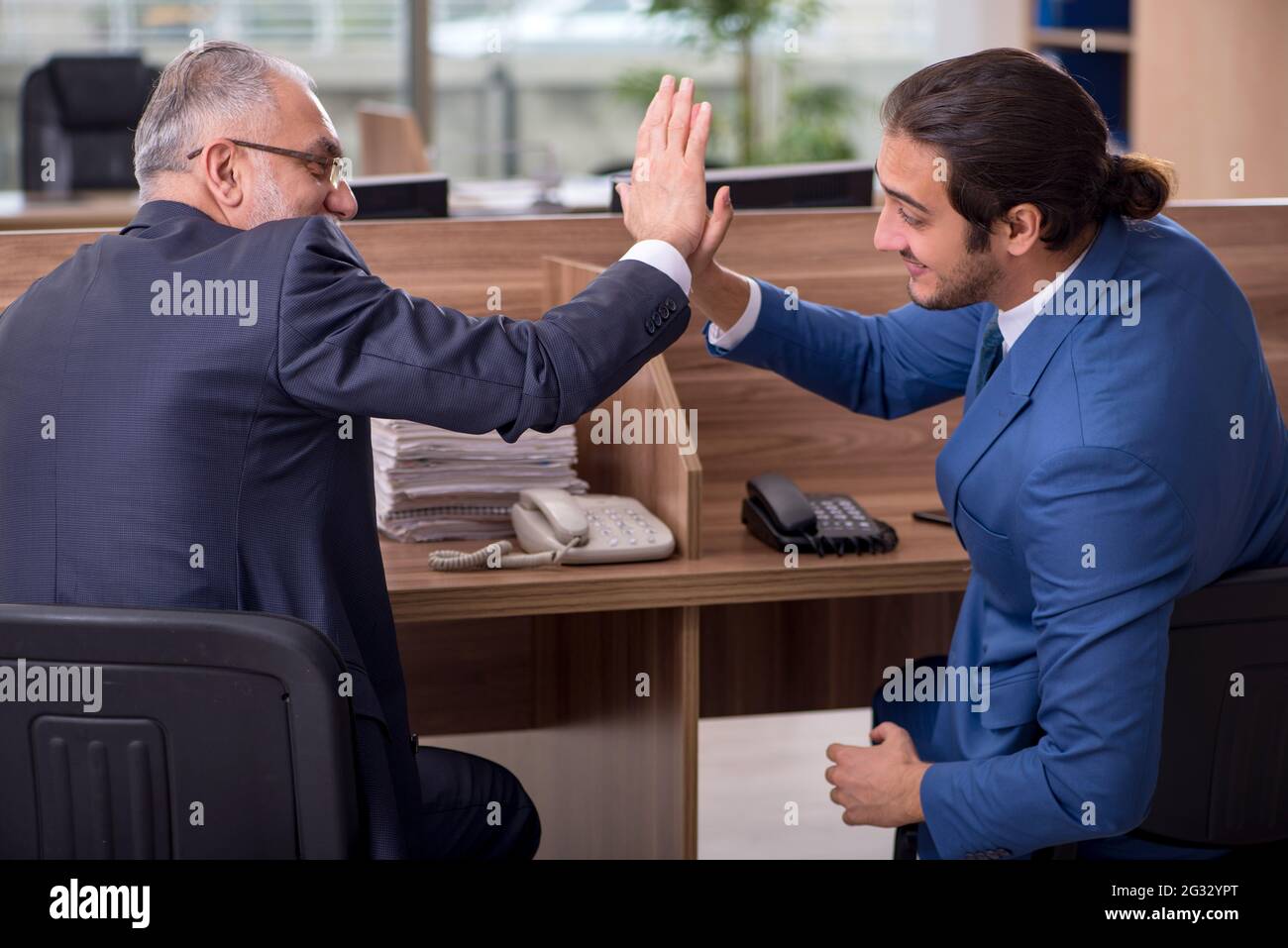 Two businessmen celebrating desk hi-res stock photography and images ...