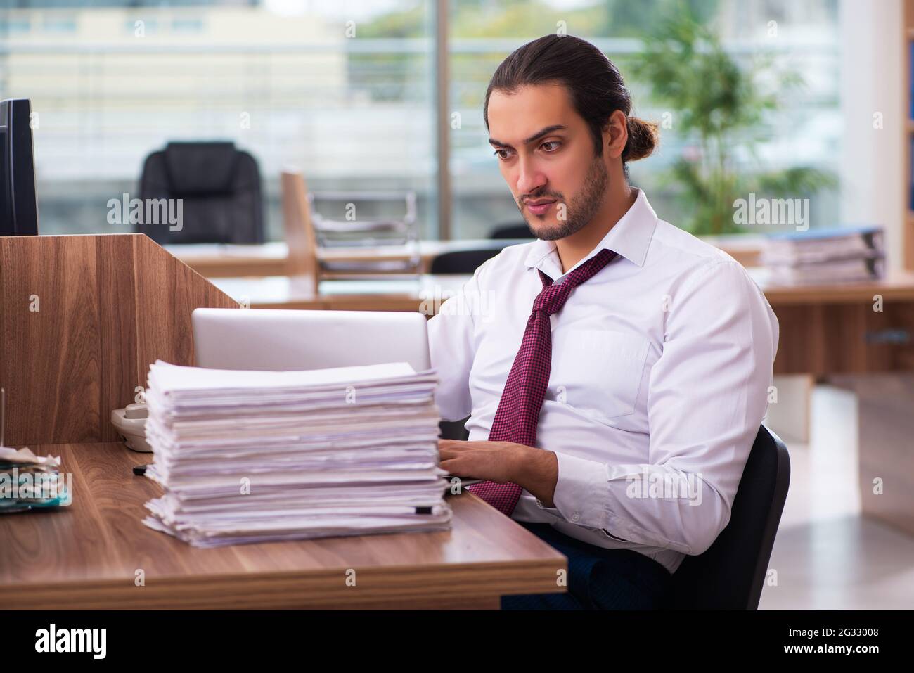 Young employee and too many work in the office Stock Photo - Alamy