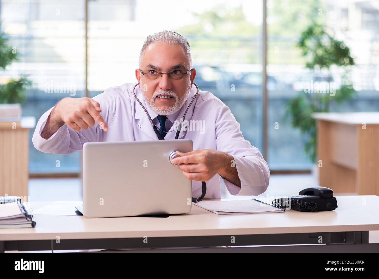 Old doctor working in the clinic Stock Photo - Alamy