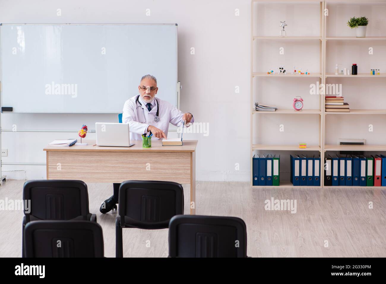 Old doctor lecturer in the classroom during pandemic Stock Photo - Alamy