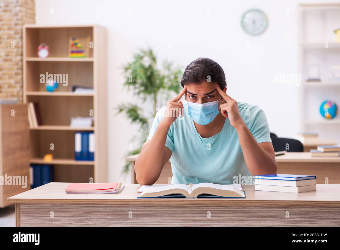 Young student sitting in the classroom wearing mask Stock Photo - Alamy